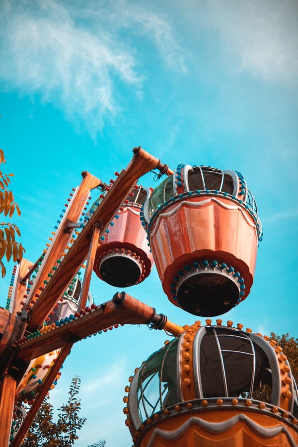Vertical Shot of Orange Rides in the Amusement Park with Blue Sky in ...