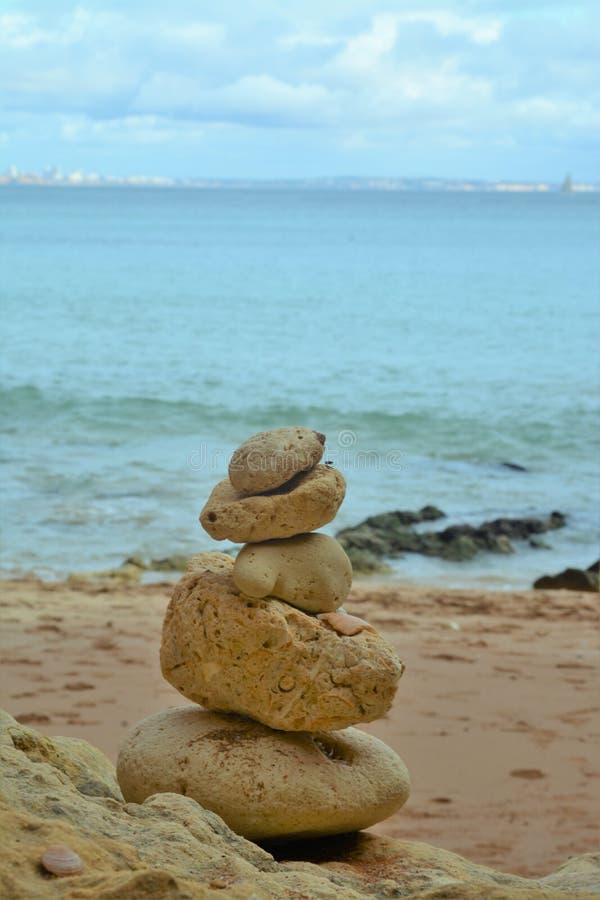 Vertical Shot of Pebbles on the Beach Balanced Perfectly on Top of Each ...