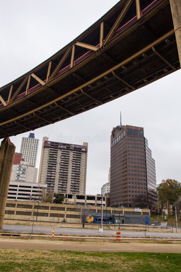 Vertical Shot of a Pedestrian Bridge Over a Road with High Buildings in ...