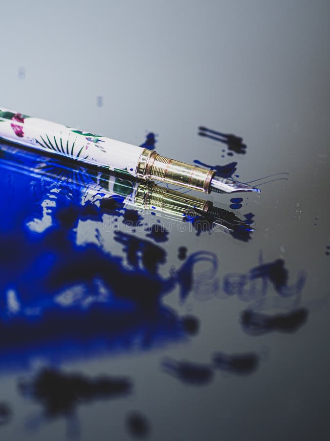 Vertical Shot of a Pen on a Mirror Table, with Ink Splashed All Over it ...