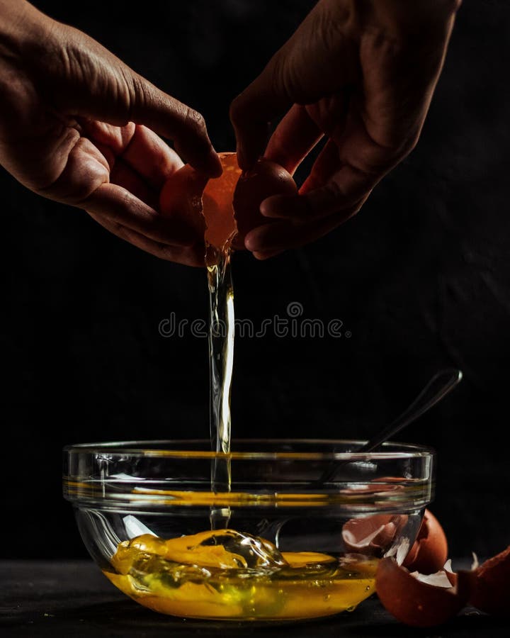 Vertical Shot of a Person Cracking an Egg into a Glass Bowl Stock Photo ...