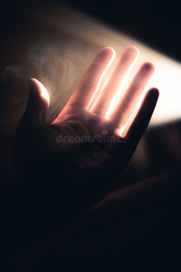 Vertical Shot of a Person S Hand Illuminated in the Dark, with a Beam ...