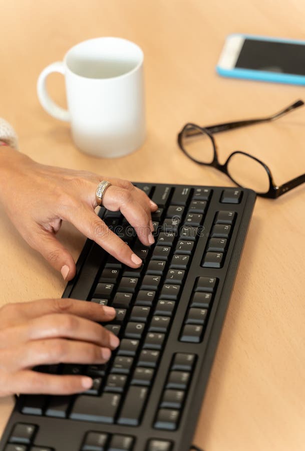 Vertical Shot of a Person Typing on a Keyboard of a Computer during the ...