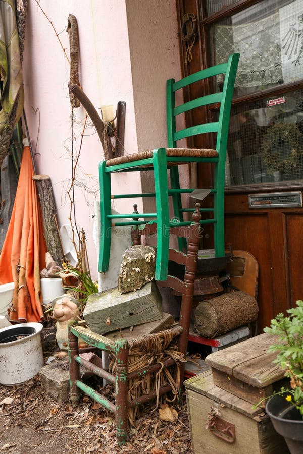 Vertical Shot of a Pile of Trash Including Old Chairs Outside a House ...