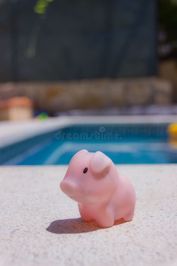 Vertical Shot of a Pink Piglet Toy on a Ledge Over a Pool Stock Photo ...