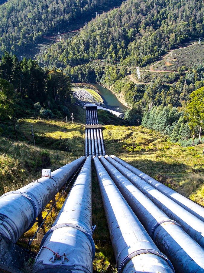 Vertical Shot of Pipes in a Landscape Surrounded by Trees and Mountains ...
