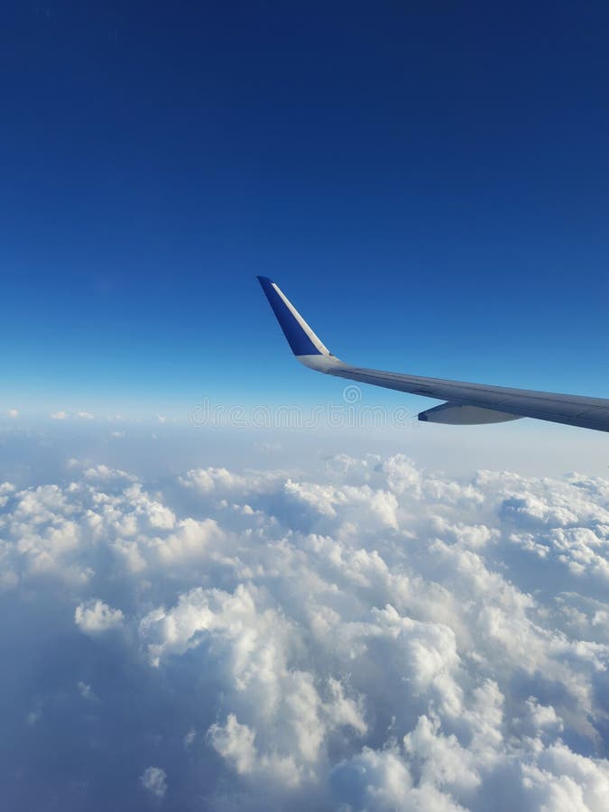 Vertical Shot of a Plane Wing Over the Clouds in Blue Sky Stock Photo ...