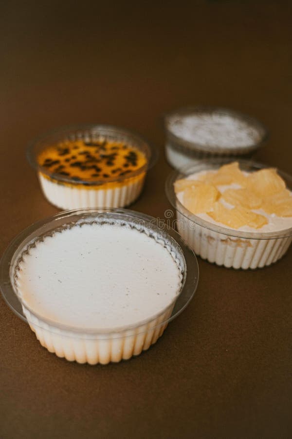 Vertical Shot of Plastic Bowls of Various Creamy Puddingf on a Brown ...