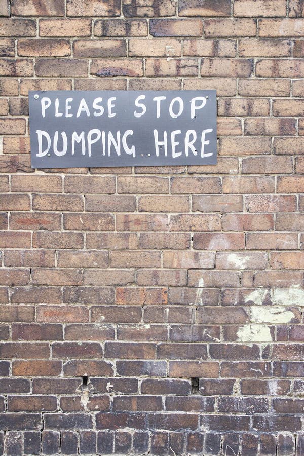Vertical Shot of a Please Stop Dumping Here Sign on a Brick Wall Stock ...