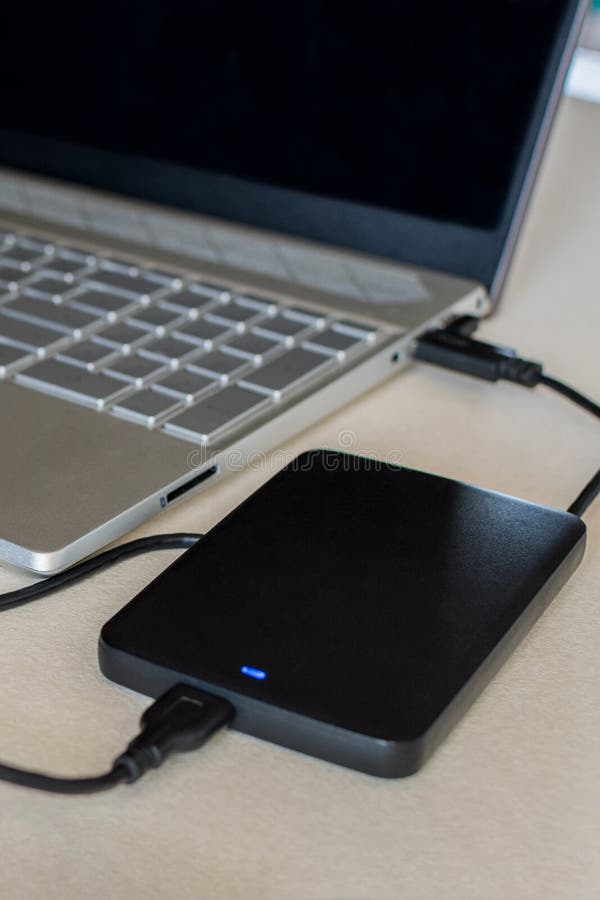 Vertical Shot of Portable Hard Drive Connected To a Laptop - Concept of ...