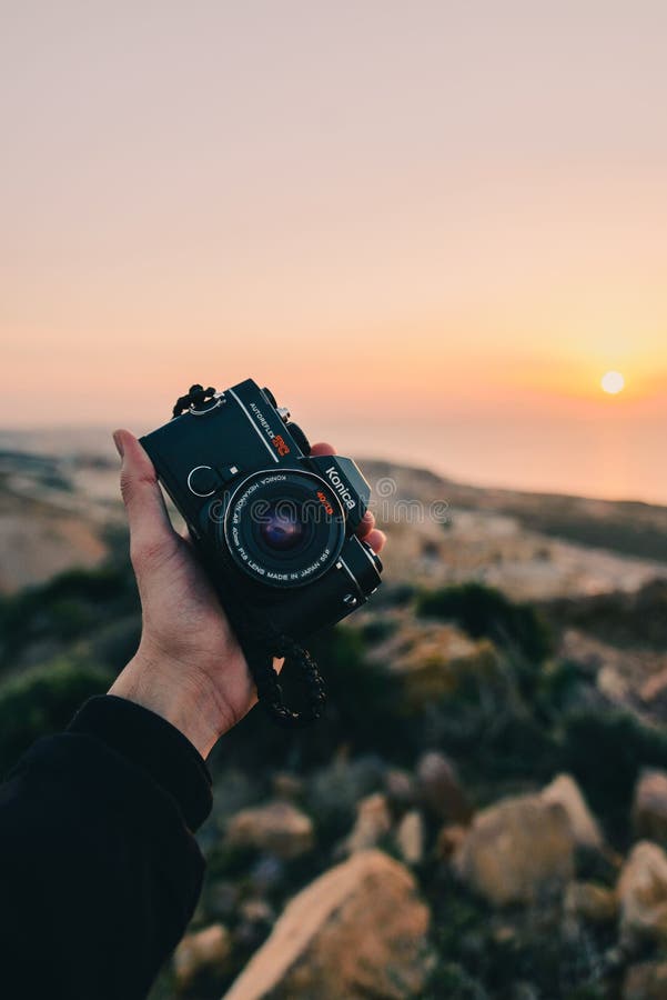 Vertical Shot of a Professional Camera in a Hand on the Background of a ...
