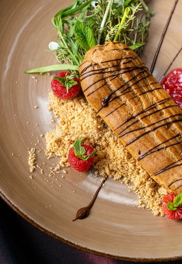 Vertical Shot of a Raspberry Eclair Served with Crushed Biscuits Leaves ...