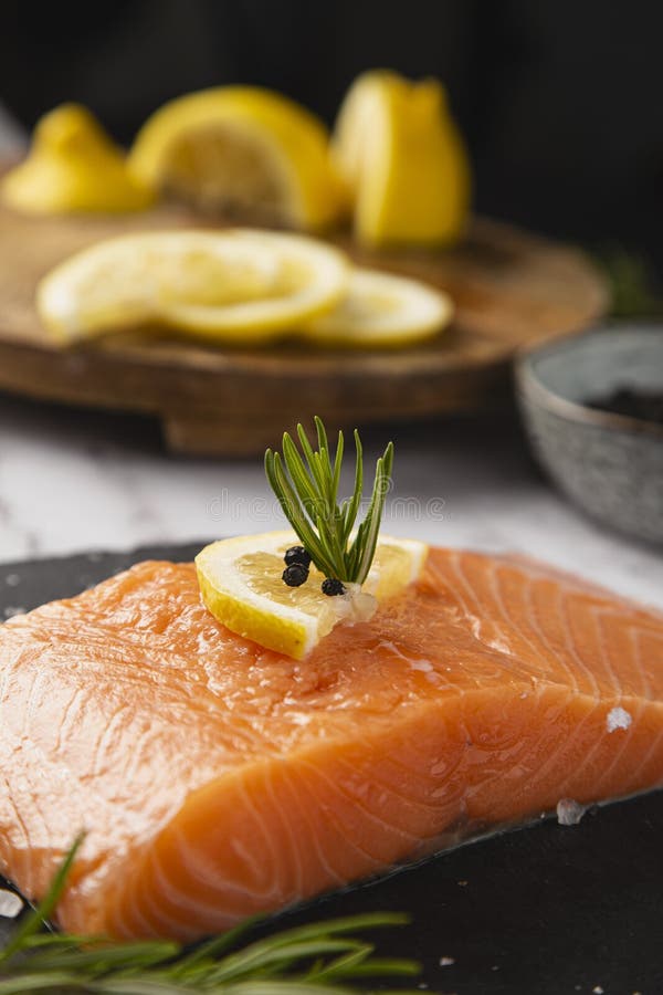 Vertical Shot of Raw Salmon Fillet with a Lemon Slice and Rosemary on ...