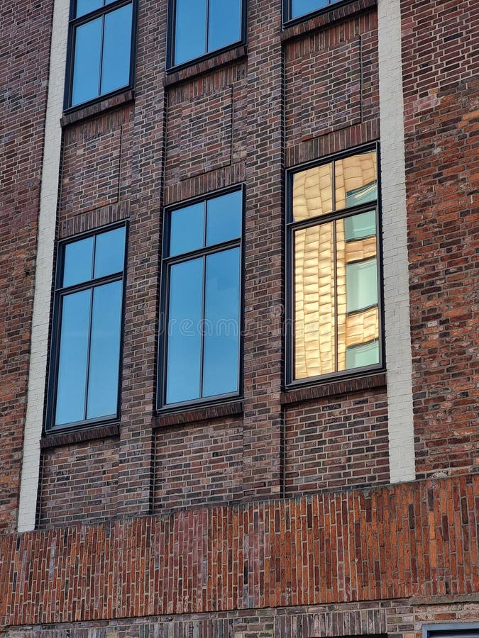Vertical Shot of a Red Brick Building with Mirror Reflecting Windows ...