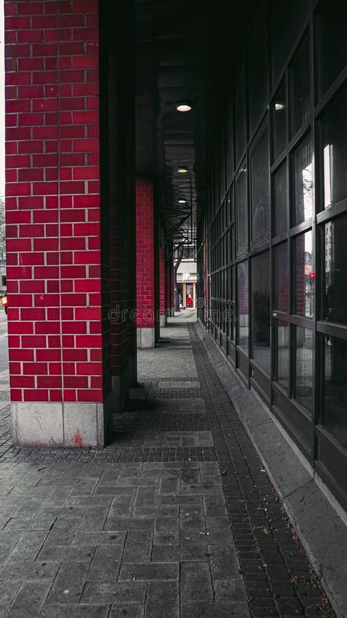 Vertical Shot of Red Brick Pillars in Front of a Building with Glass ...