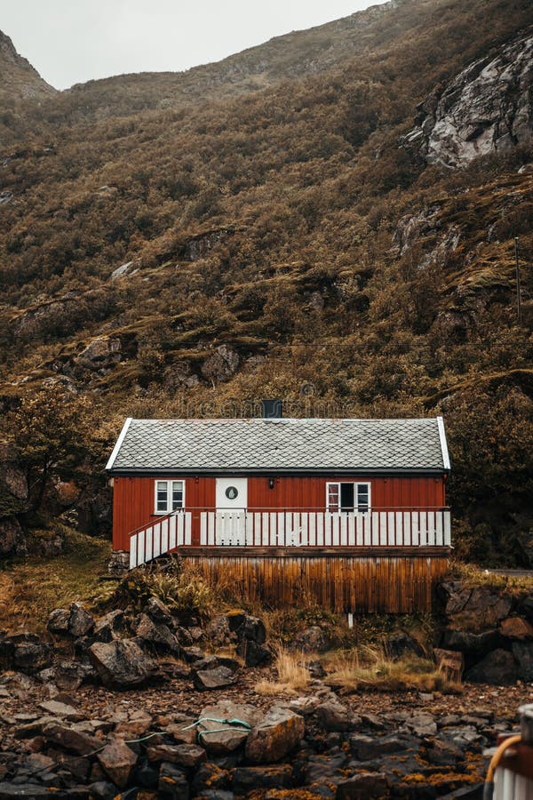 Vertical Shot of a Red Cabin Near Mountains and Rocks Stock Photo ...