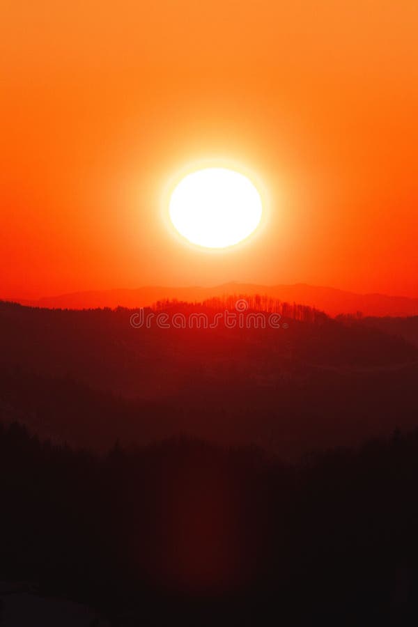 Vertical Shot of a Red Cloudless Sunset Above the Forest Mountains ...