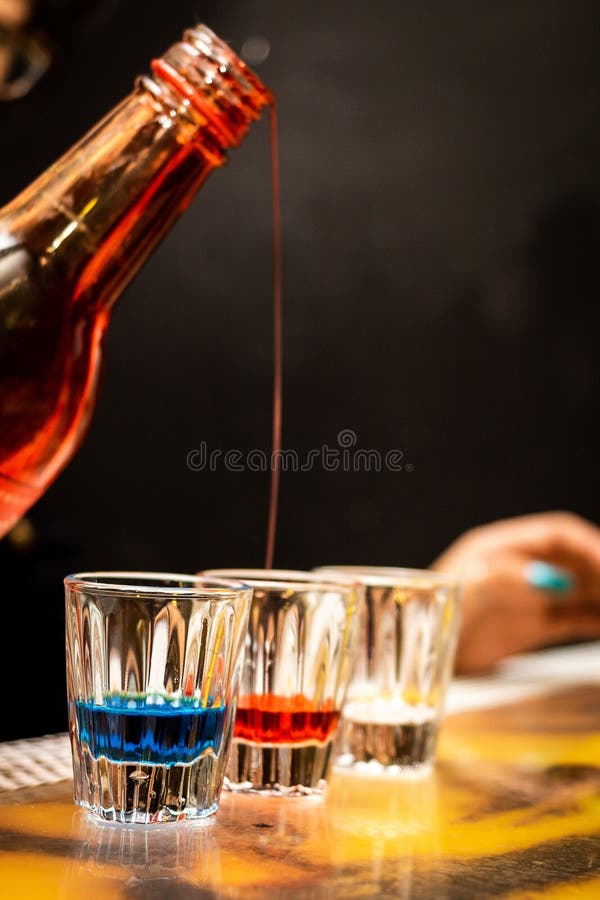 Vertical Shot of a Red Drink Being Poured into a Glass on the Bar Stand ...
