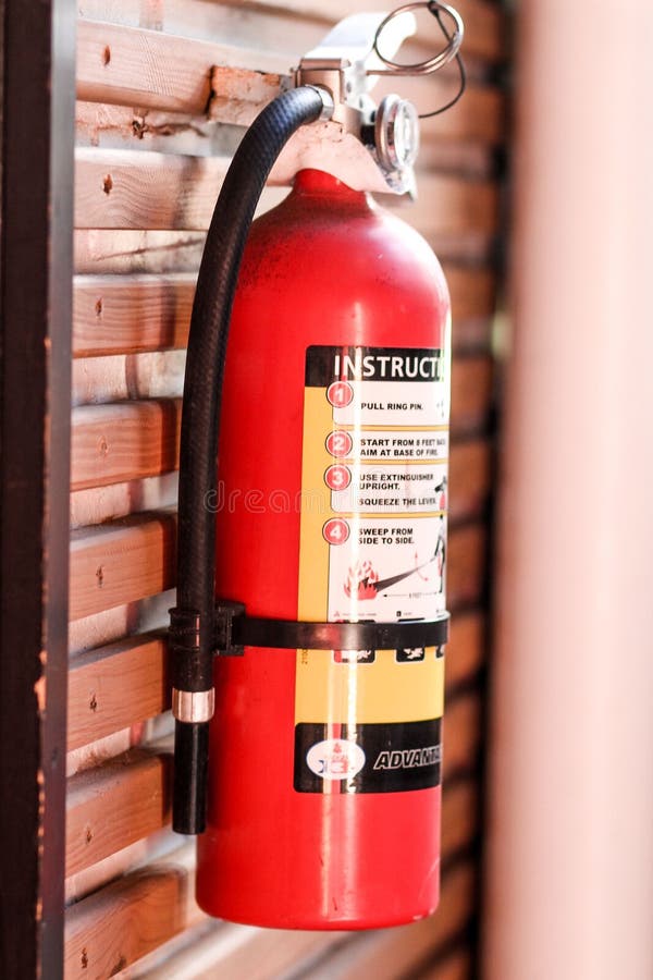 Vertical Shot of a Red Fire Extinguisher Hanging on a Wall Inside a ...
