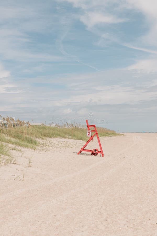 Vertical Shot of a Red Lifeguard Chair on the Sandy Beach Stock Photo ...