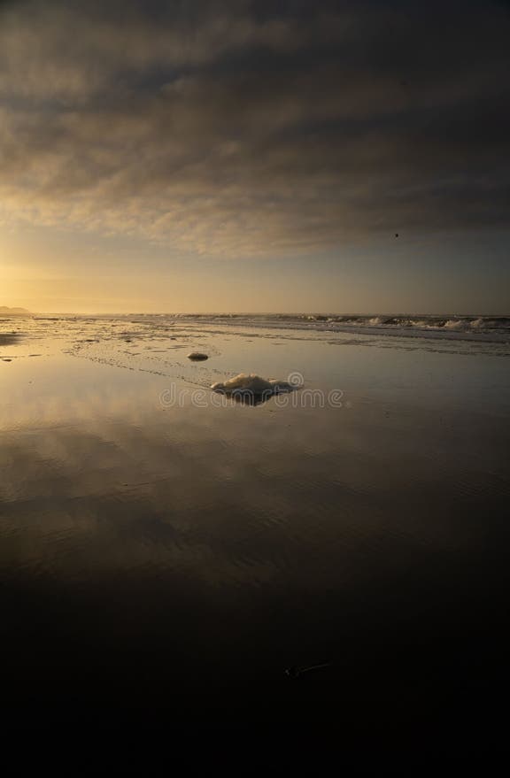 Vertical Shot of Reflective Shallow Waters of a Beach at Sunset Stock ...