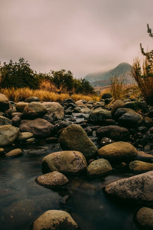 Vertical Shot of a River with Rocks in a Beautiful Fall Scenery with a ...