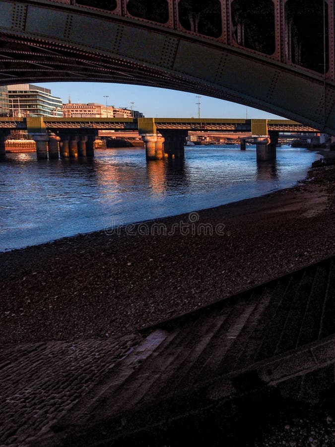 Vertical Shot of the River Under the Metal Bridges with the Buildings ...