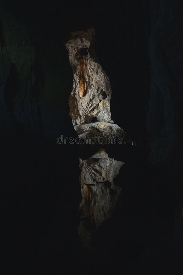 Vertical Shot of the Rocky Cliff Partially Under Sunlight in the Dark ...