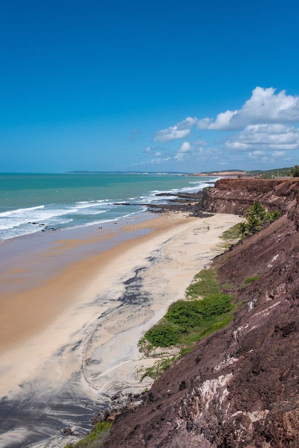 Vertical Shot of Rocky Cliffs by the Ocean Under the Cloudy Sky ...