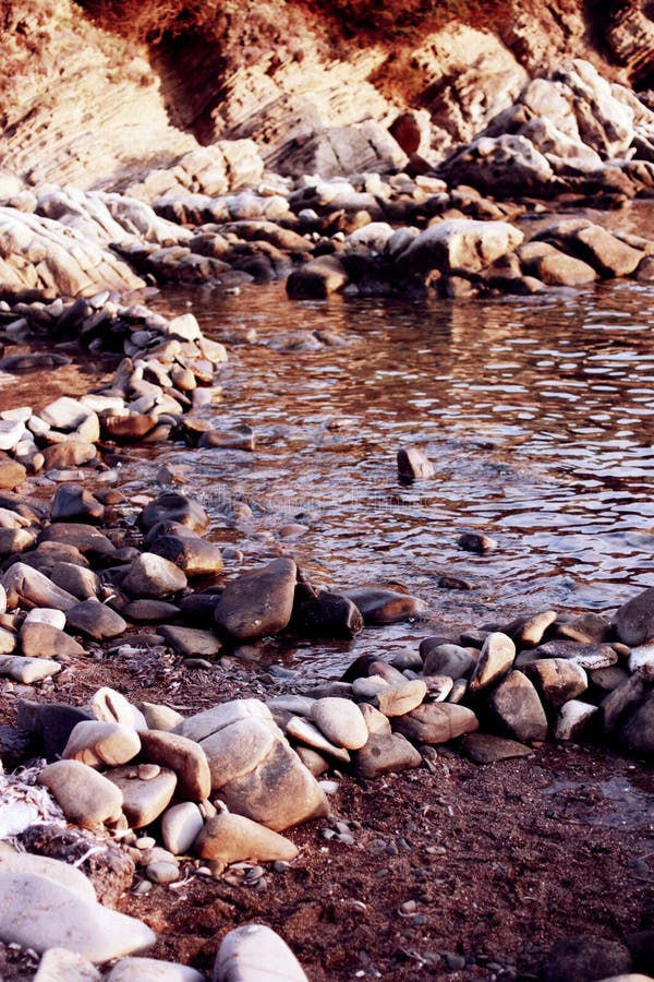 Vertical Shot of the Rocky Lakeside. Stock Photo - Image of beach ...