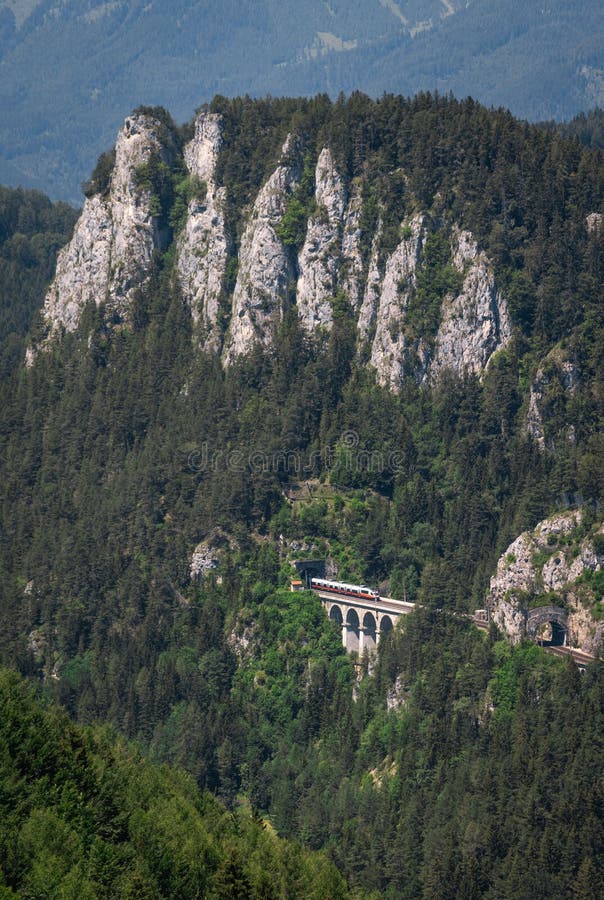 Vertical Shot of Rocky Mountains with a Train on a Viaduct Bridge Stock ...