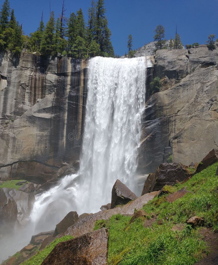 Vertical Shot of a Rocky Waterfall with Splashing Water on a Bright ...