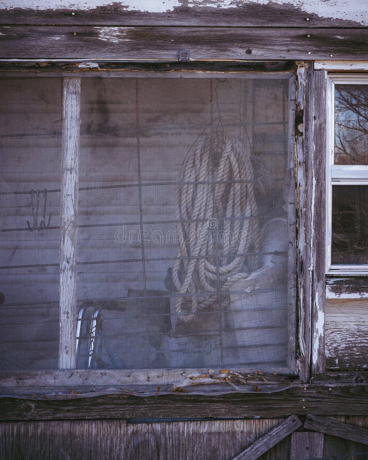 Vertical Shot of a Rope Seen through a Screen of an Abandoned House in ...