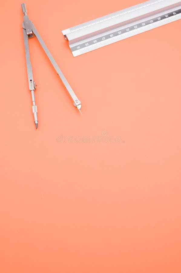 Vertical Shot of a Ruler and Compass on an Orange Background with a ...