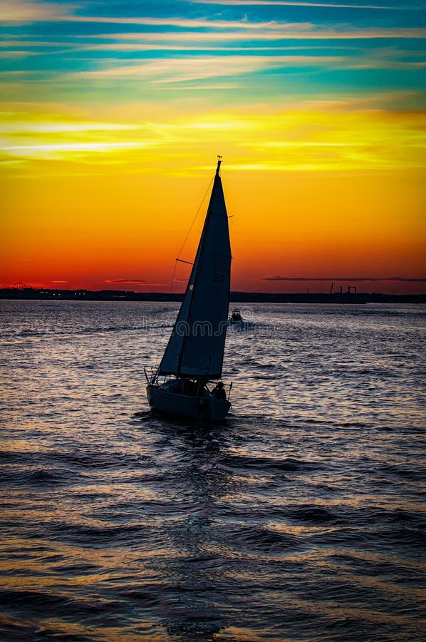Vertical Shot of a Sailing Ship Flowing Under the Breathtaking Sunset ...