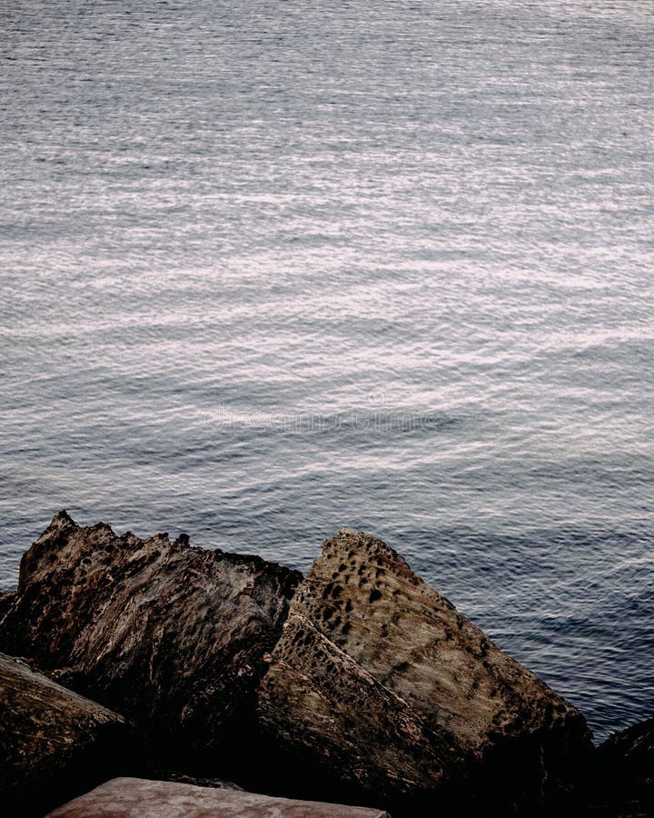 Vertical Shot of Sea Water with Rocks on the Coast Stock Image - Image ...