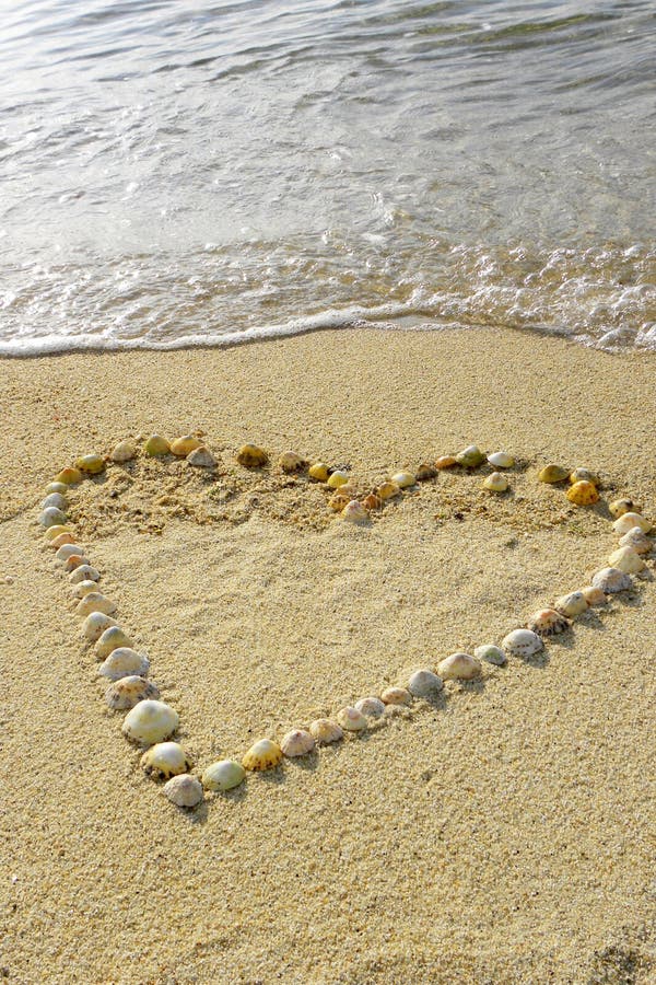 Vertical Shot of Seashells Forming a Heart Shape on the Beach ...