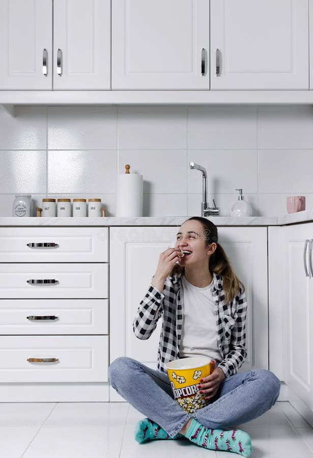 Vertical Shot of a Serbian Female Eating Popcorn Sitting on the Kitchen ...