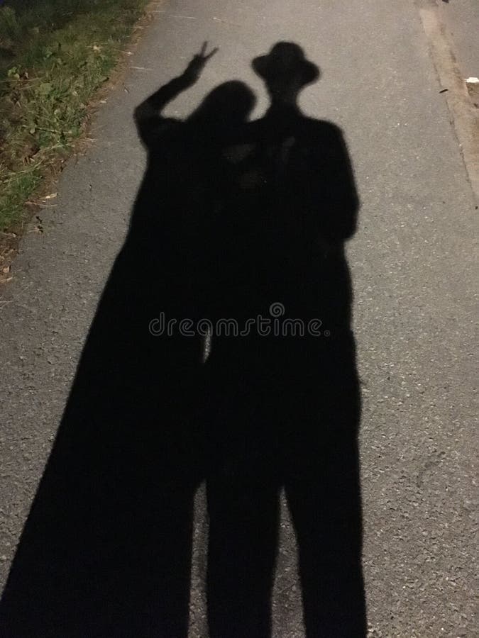 Vertical Shot a Shadow on the Asphalt of a Couple Posing Stock Photo ...