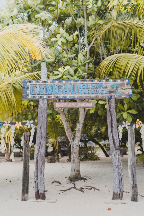 Vertical Shot of a Sign Reading Island Paradise in Front of the Trees ...