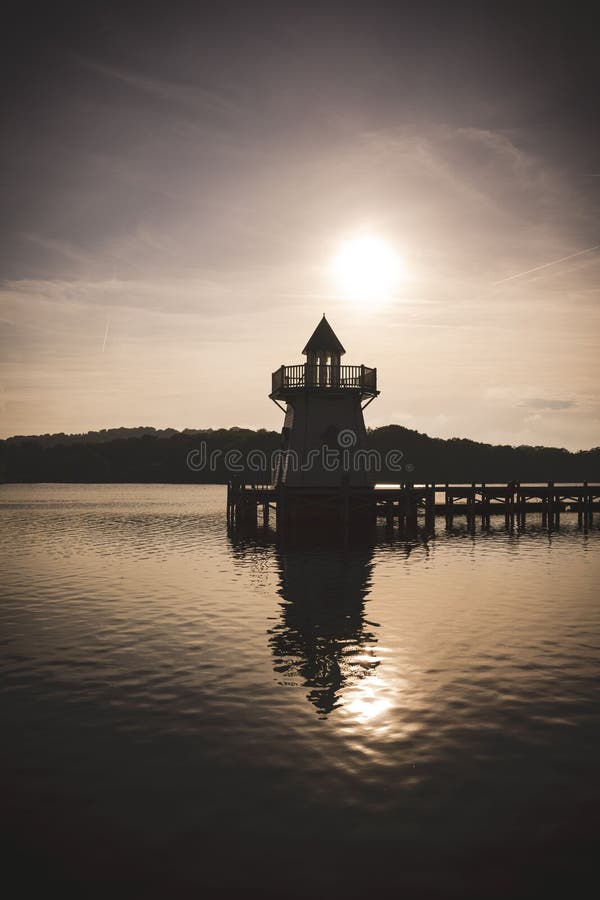 Silhouette of Lighthouse and a Yacht during Sunset Near Cape Henlopen ...