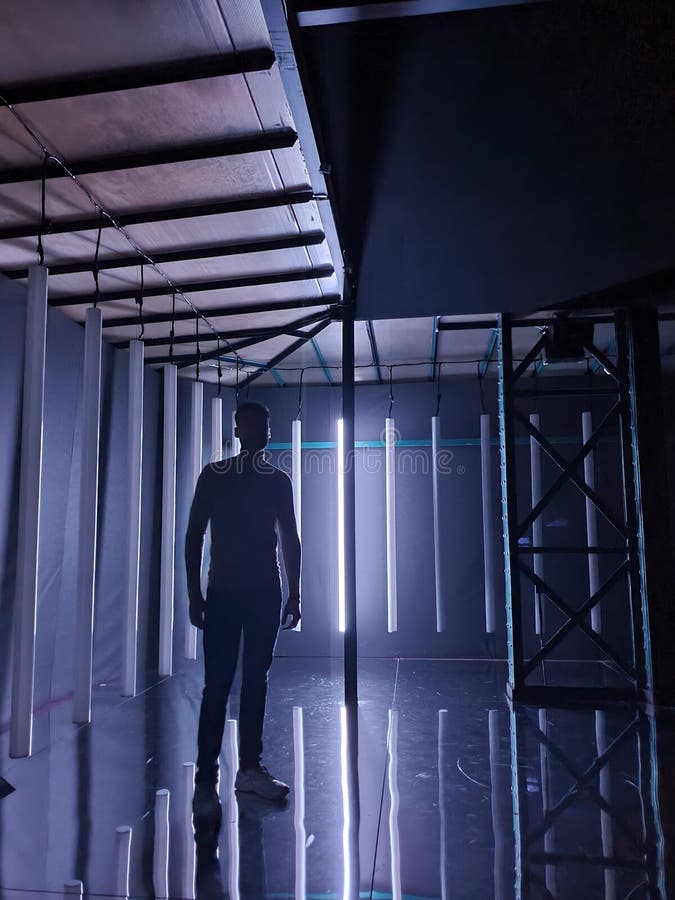 Vertical Shot of a Silhouette of a Person in the Dark Room with Modern ...