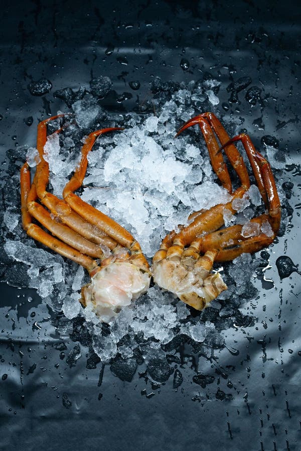 Vertical Shot of Sliced Pieces of a Crab on Ice on a Dark Background ...