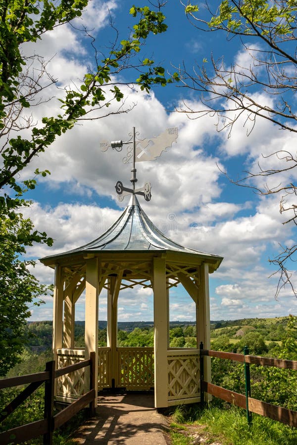 Vertical Shot of a Small Tower in Front of a Forest Under a Cloudy Sky ...