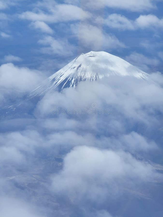 Vertical Shot of a Snowy Mount Behind the Clouds Stock Image - Image of ...