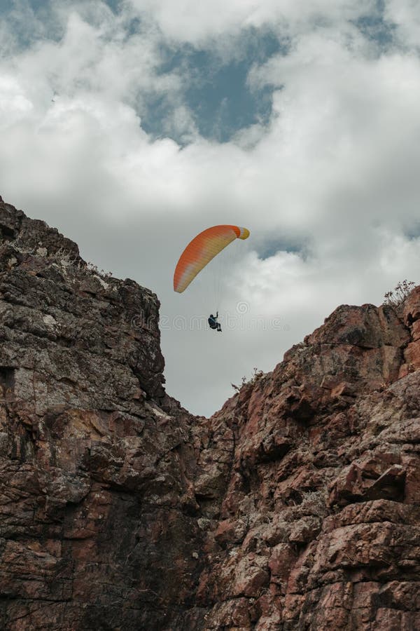 Vertical Shot of a Solo Paraglider Over a Cliff Stock Photo - Image of ...