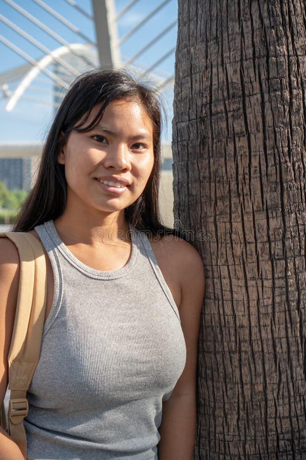 Vertical Shot of the Southeast Asian Female Leaning on the Tree Stock ...