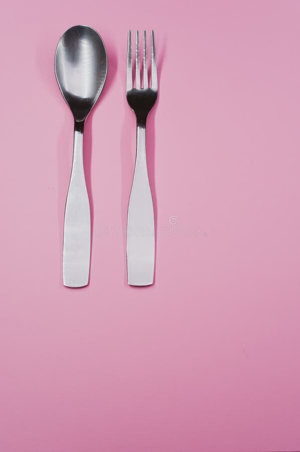 Vertical Shot of a Spoon and Fork on a Pink Surface Stock Photo - Image ...