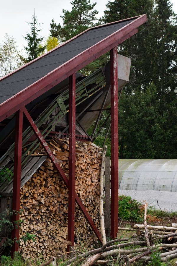 Vertical Shot of a Stacked Chopped Wood Under an Old Sorting Machine in ...