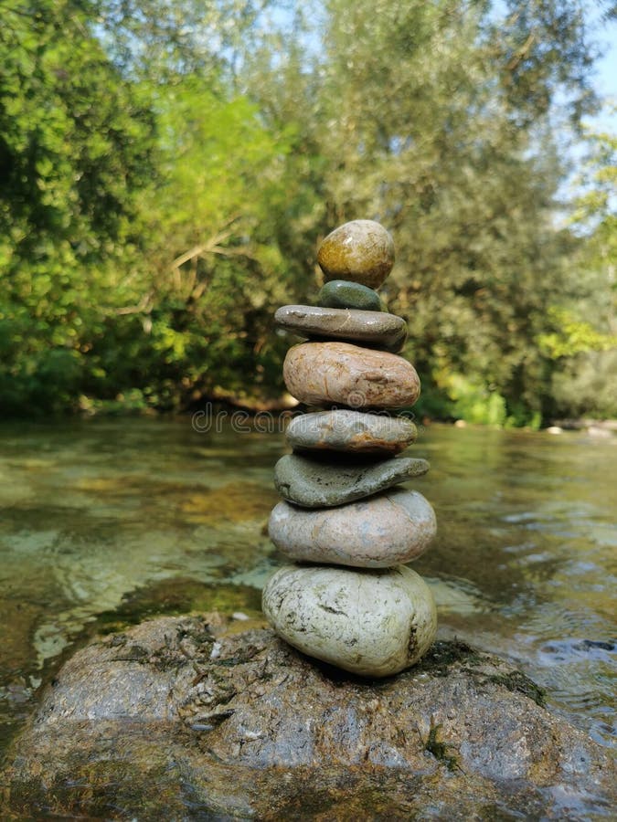 Vertical Shot of Stacked Rocks Near a River in a Park Under the ...